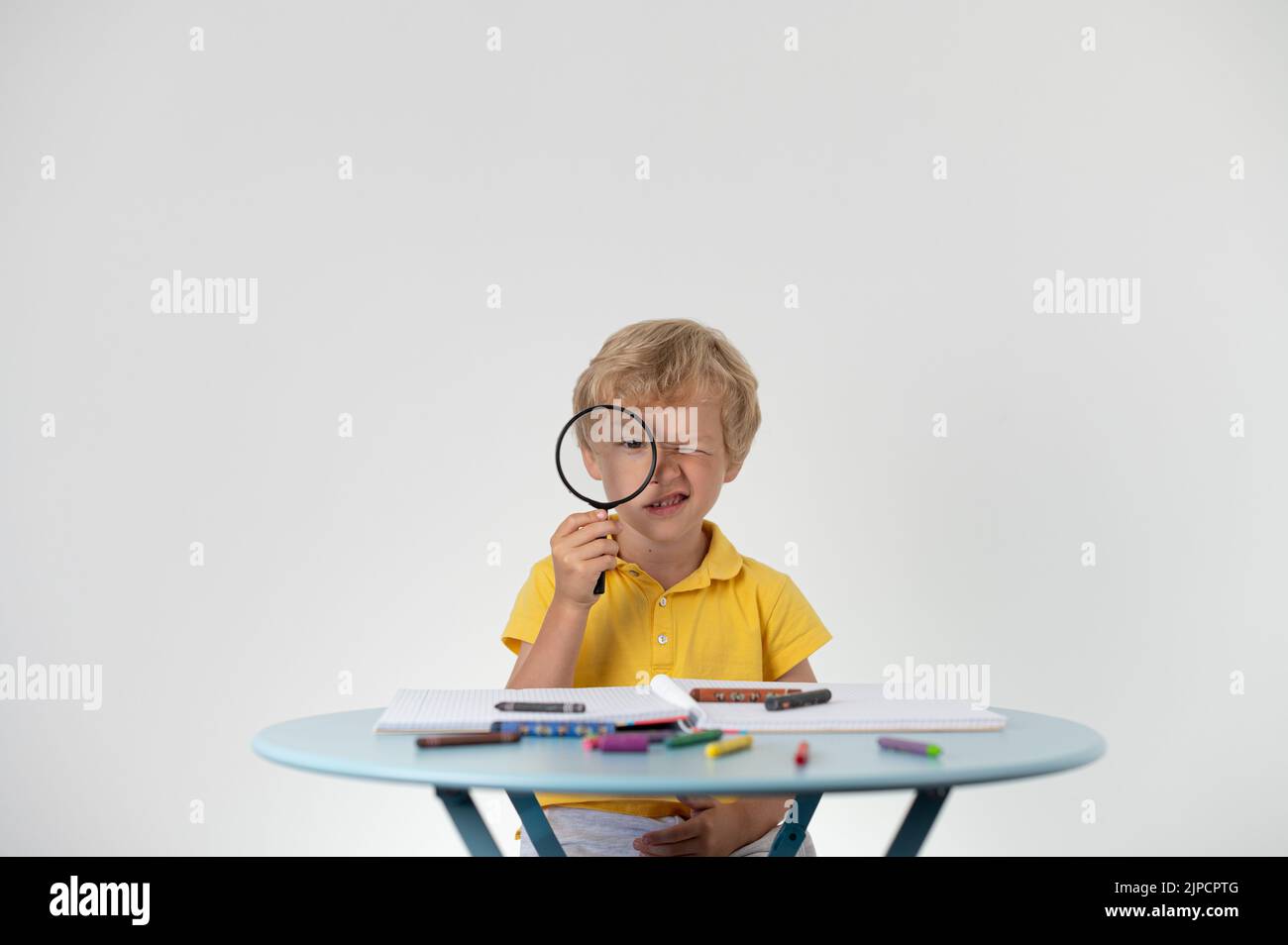 Boy with a pencil sitting at a table, school education Stock Photo - Alamy