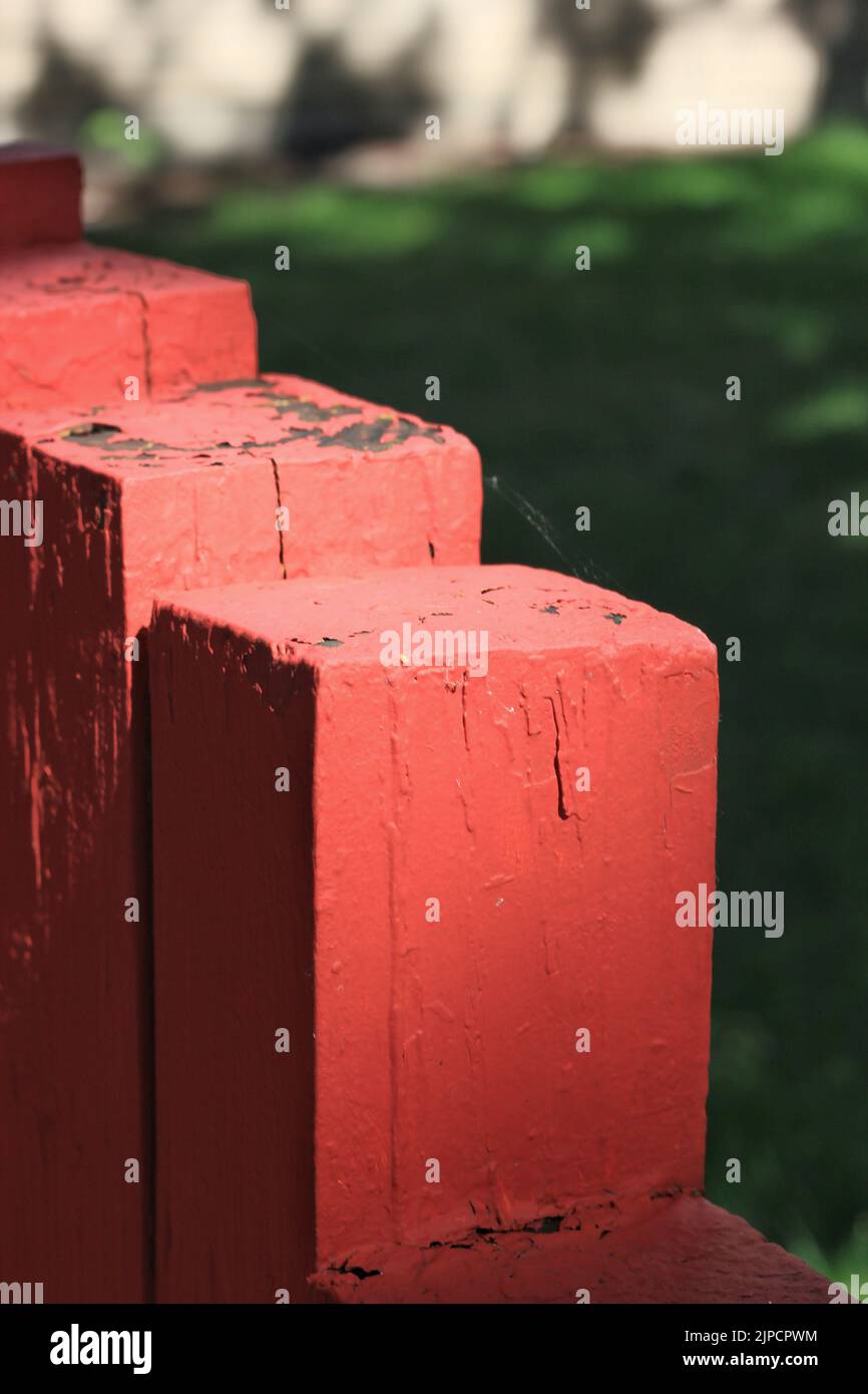 Closeup of bright red outdoor wooden posts standing as a surface for an ...