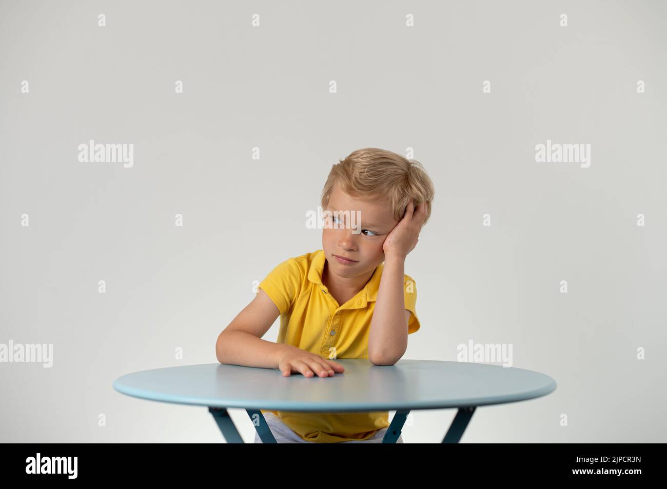 Boy with sitting at a table, school education Stock Photo - Alamy