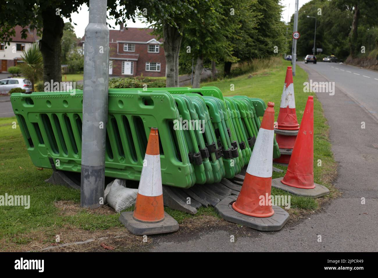 A closeup of road cones and green fencing objects aside the road Stock ...