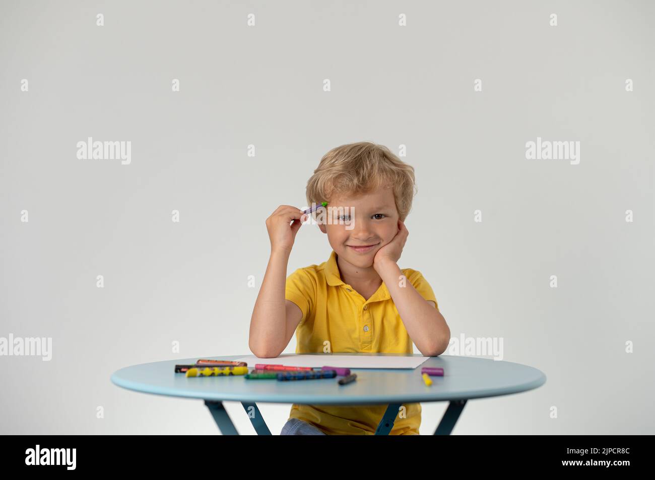 Boy with a pencil sitting at a table, school education Stock Photo - Alamy