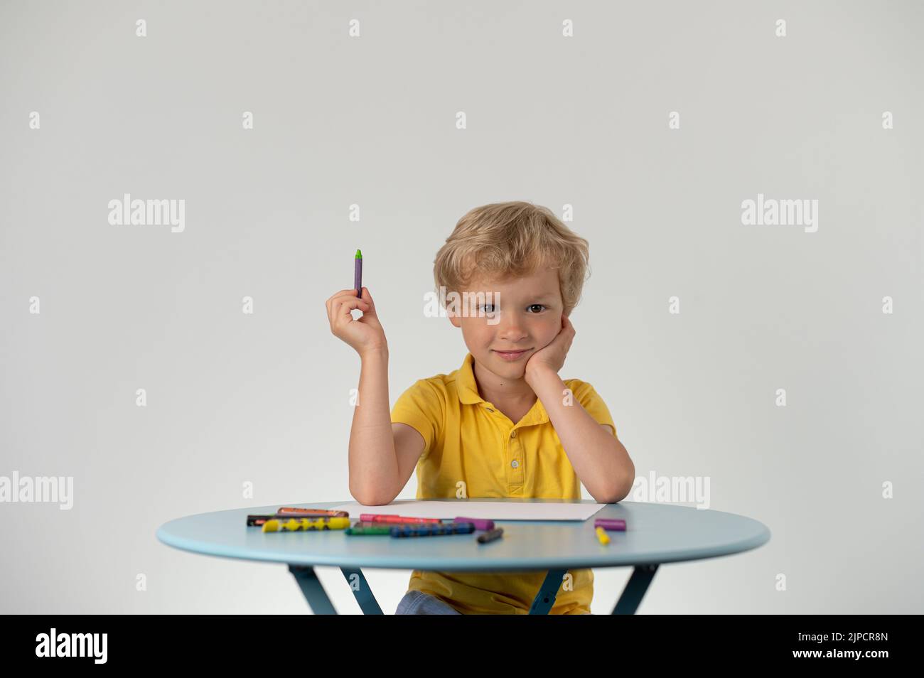 Boy with a pencil sitting at a table, school education Stock Photo - Alamy