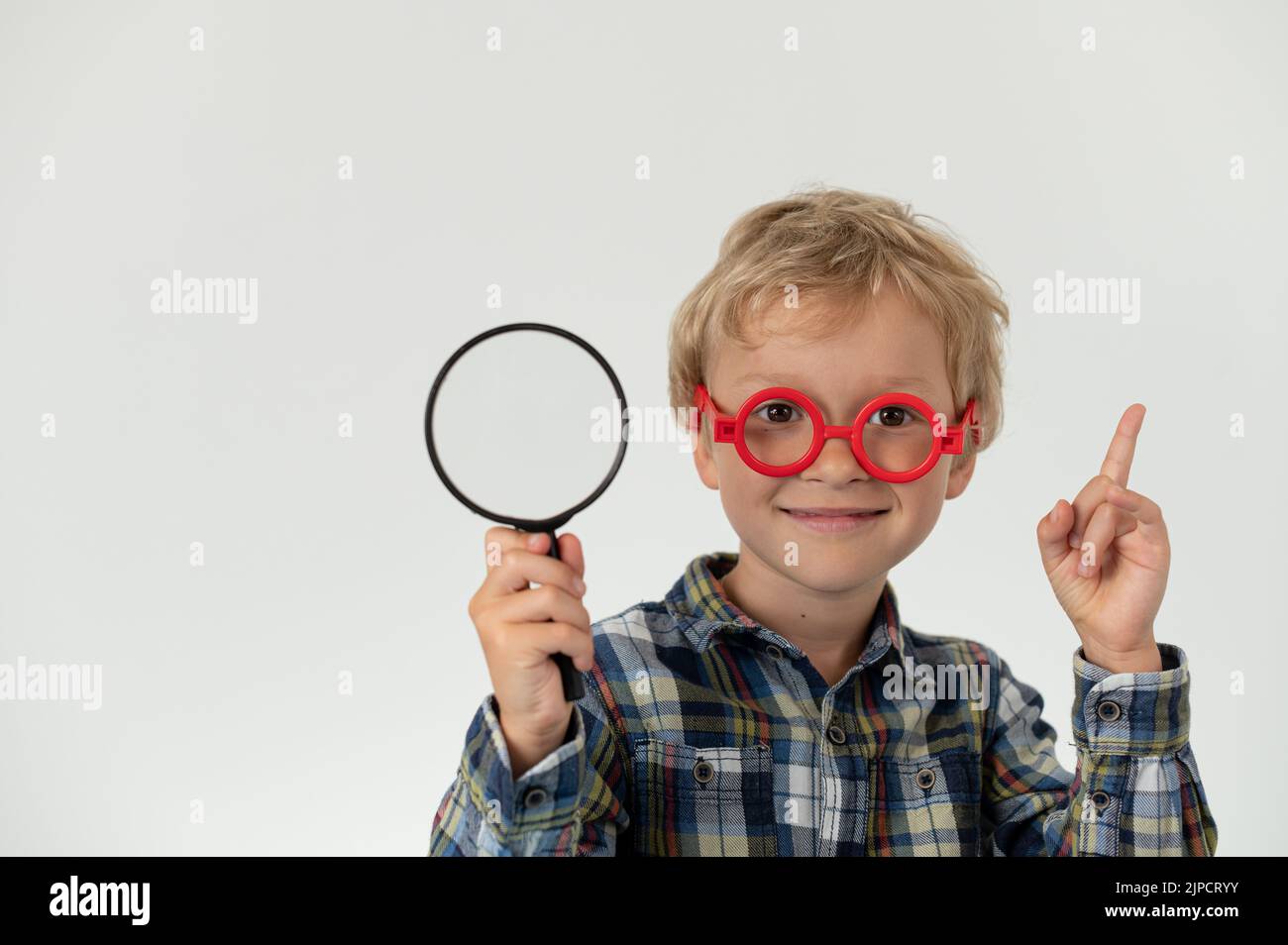 Curious school boy looking into lens Stock Photo - Alamy