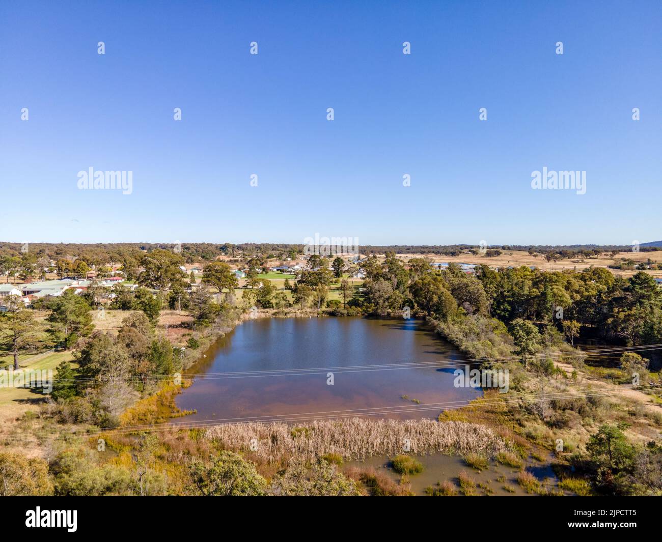An aerial view of Emmaville town in Australia surrounded by trees under ...