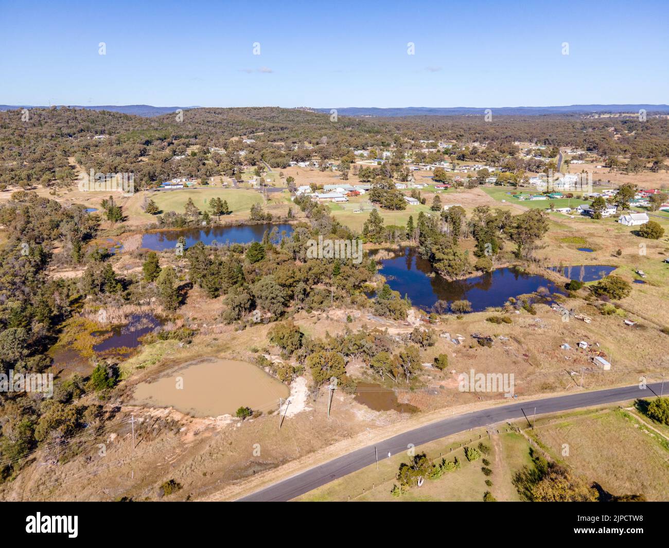 An aerial view of Emmaville town in Australia surrounded by trees under ...