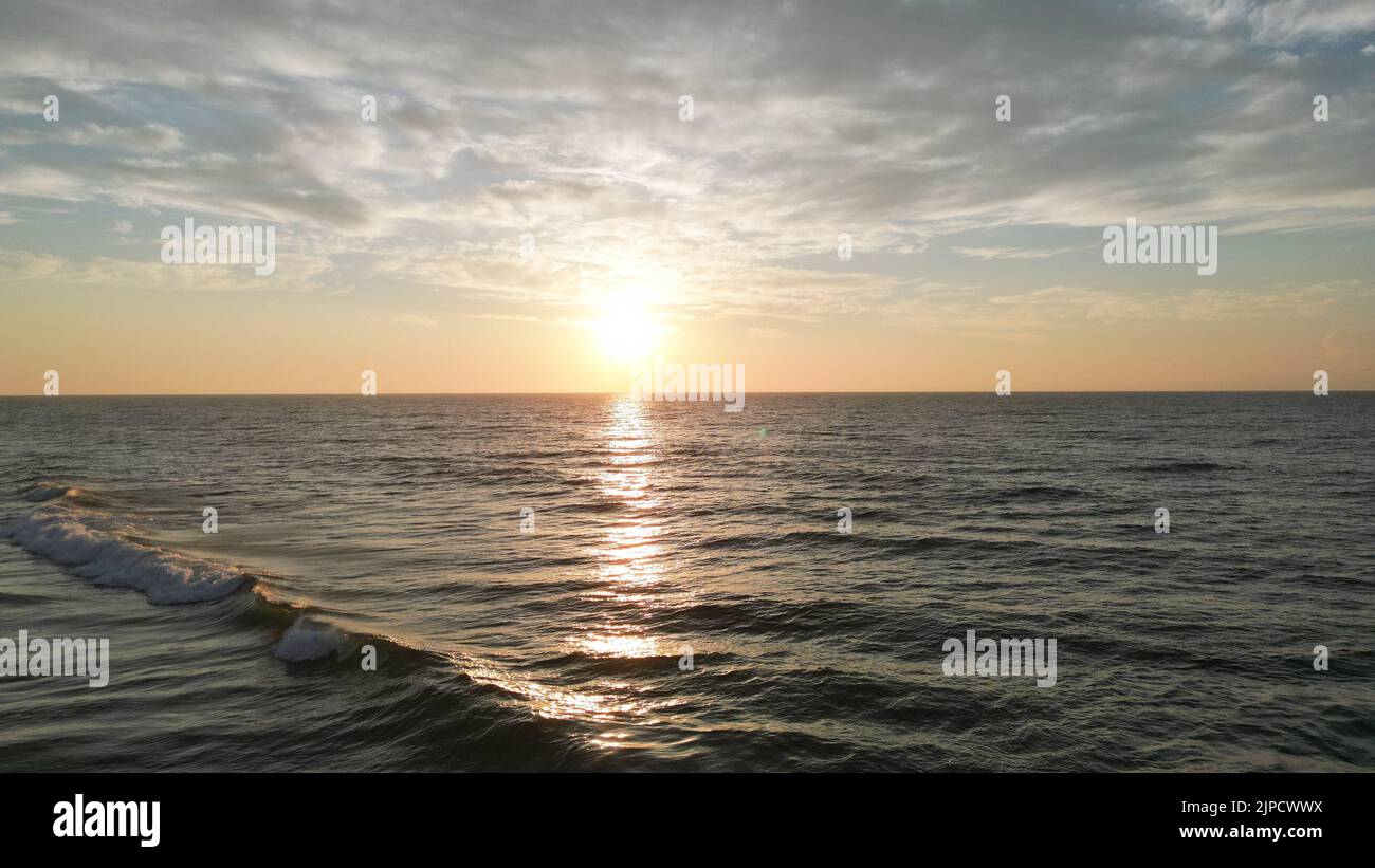 The sun rising over a beach Stock Photo - Alamy