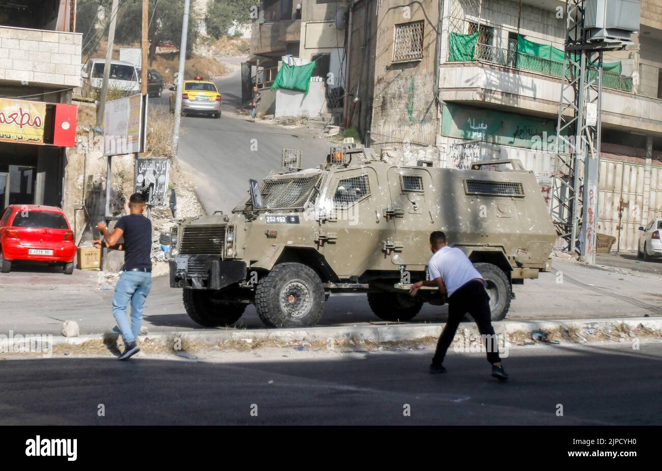 Nablus, Palestine. 17th Aug, 2022. Palestinian youths throw stones at ...