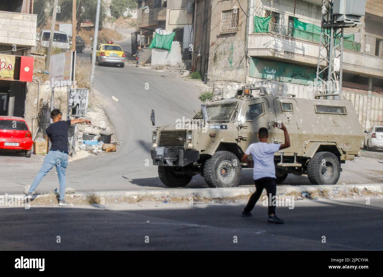 Nablus, Palestine. 17th Aug, 2022. Palestinian youths throw stones at a ...