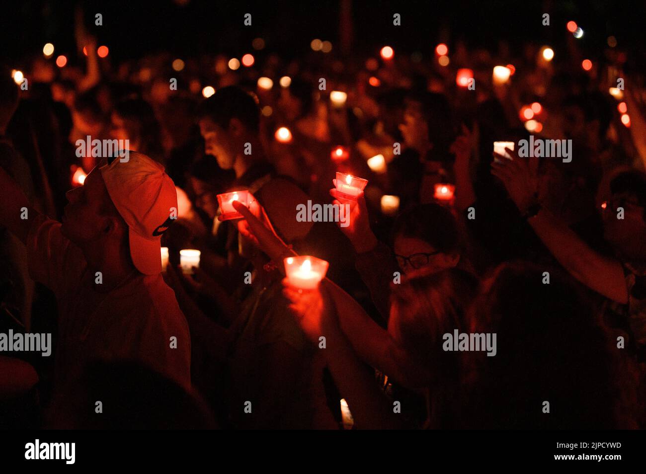 People with candles praying and singing during the veneration of the ...