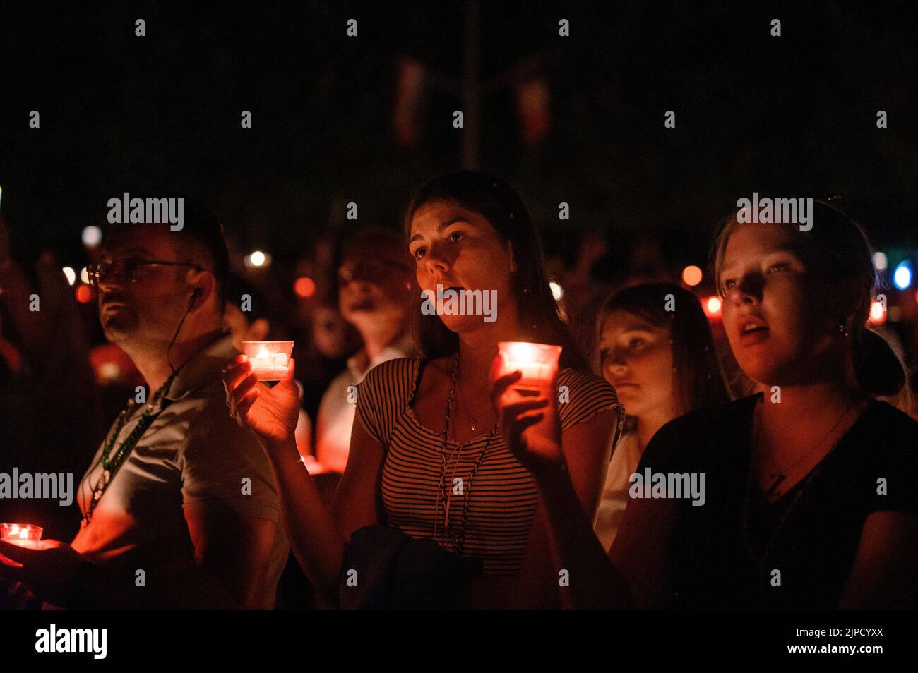 People with candles praying and singing during the veneration of the ...
