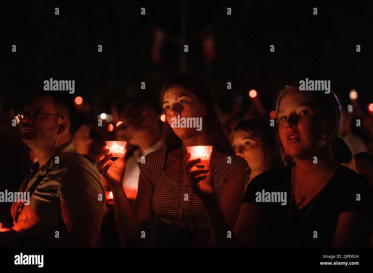 People with candles praying and singing during the veneration of the ...