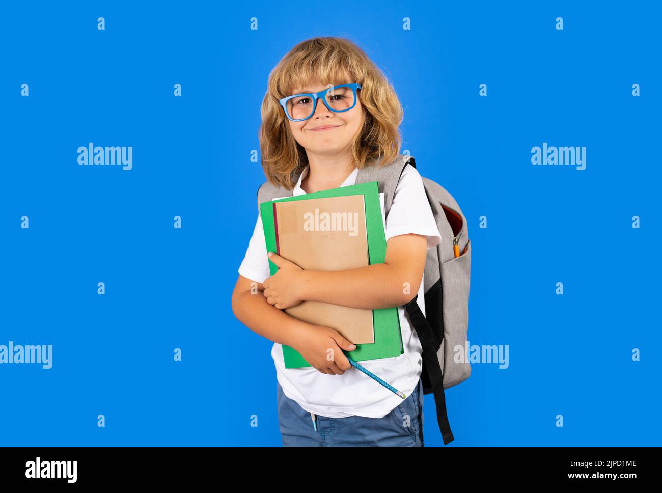 Portrait of pupil student hold book on blue isolated studio background ...