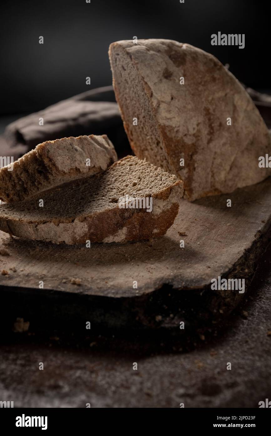 Low key food photography. Black rustic bread on dark background Stock ...