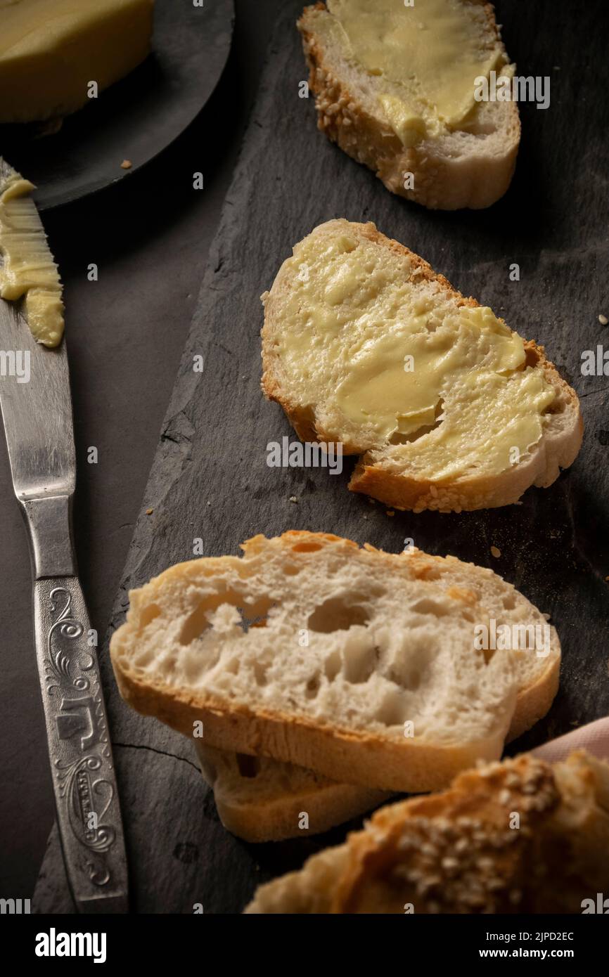 Low key food photography. Rustic bread with butter on dark background ...
