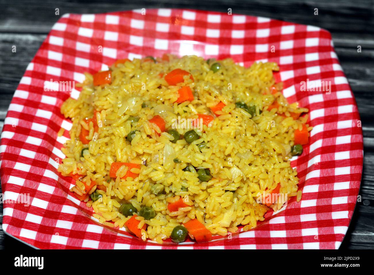 A plate of hot steamed long grain yellow Basmati rice with vegetables ...