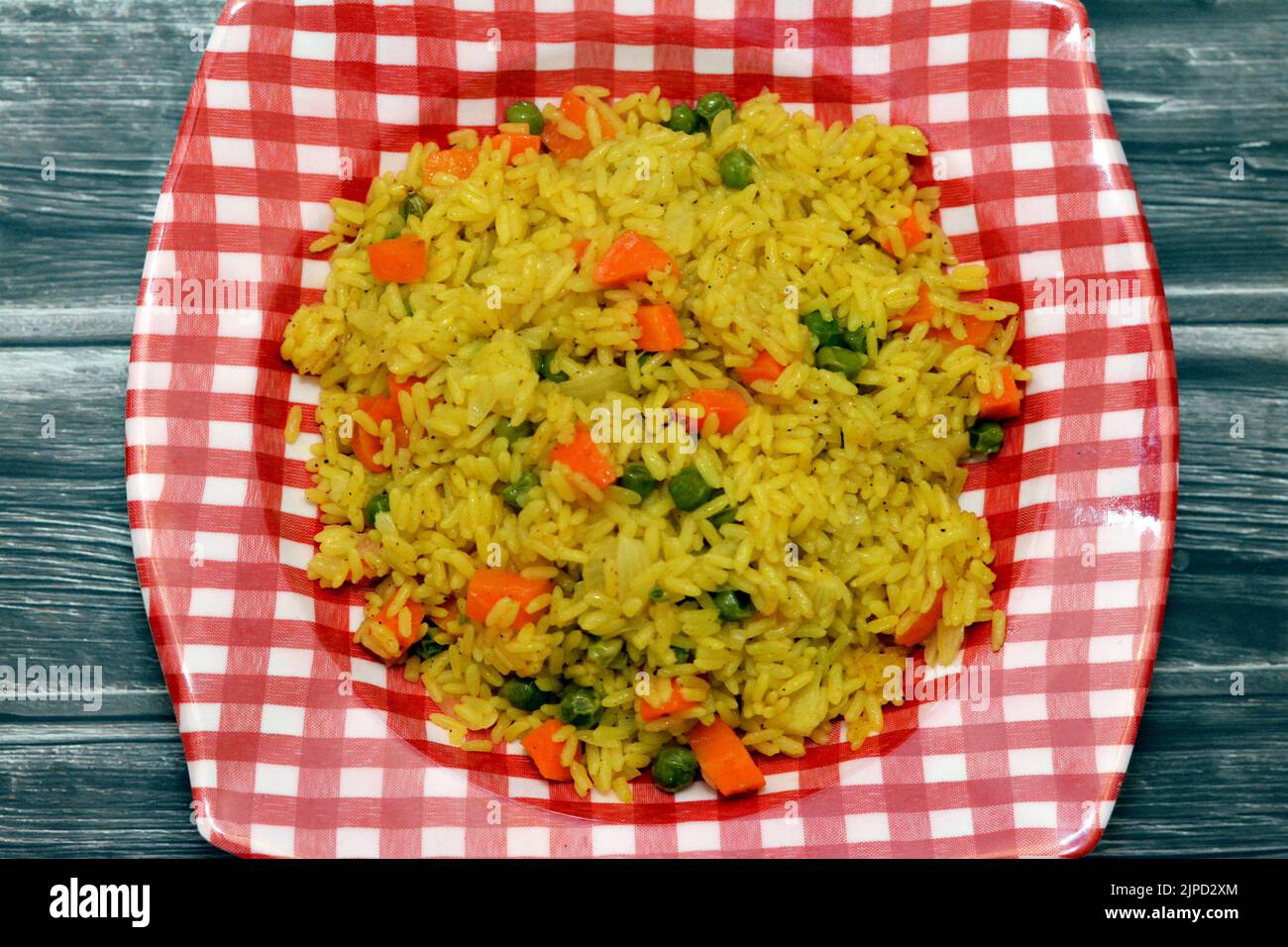 A plate of hot steamed long grain yellow Basmati rice with vegetables ...