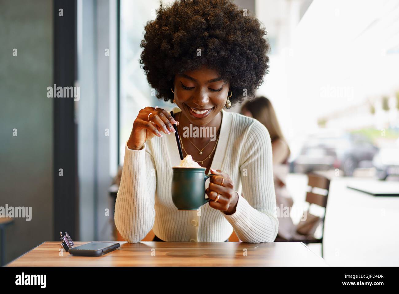 Young afro woman taking break and drinking coffee in cafe Stock Photo ...