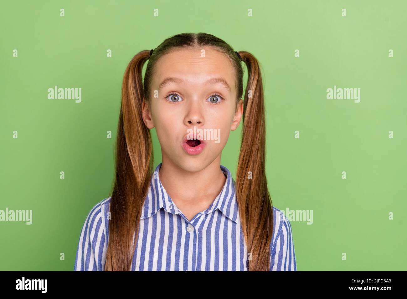 Photo of impressed pretty little schoolkid wear striped shirt big eyes ...