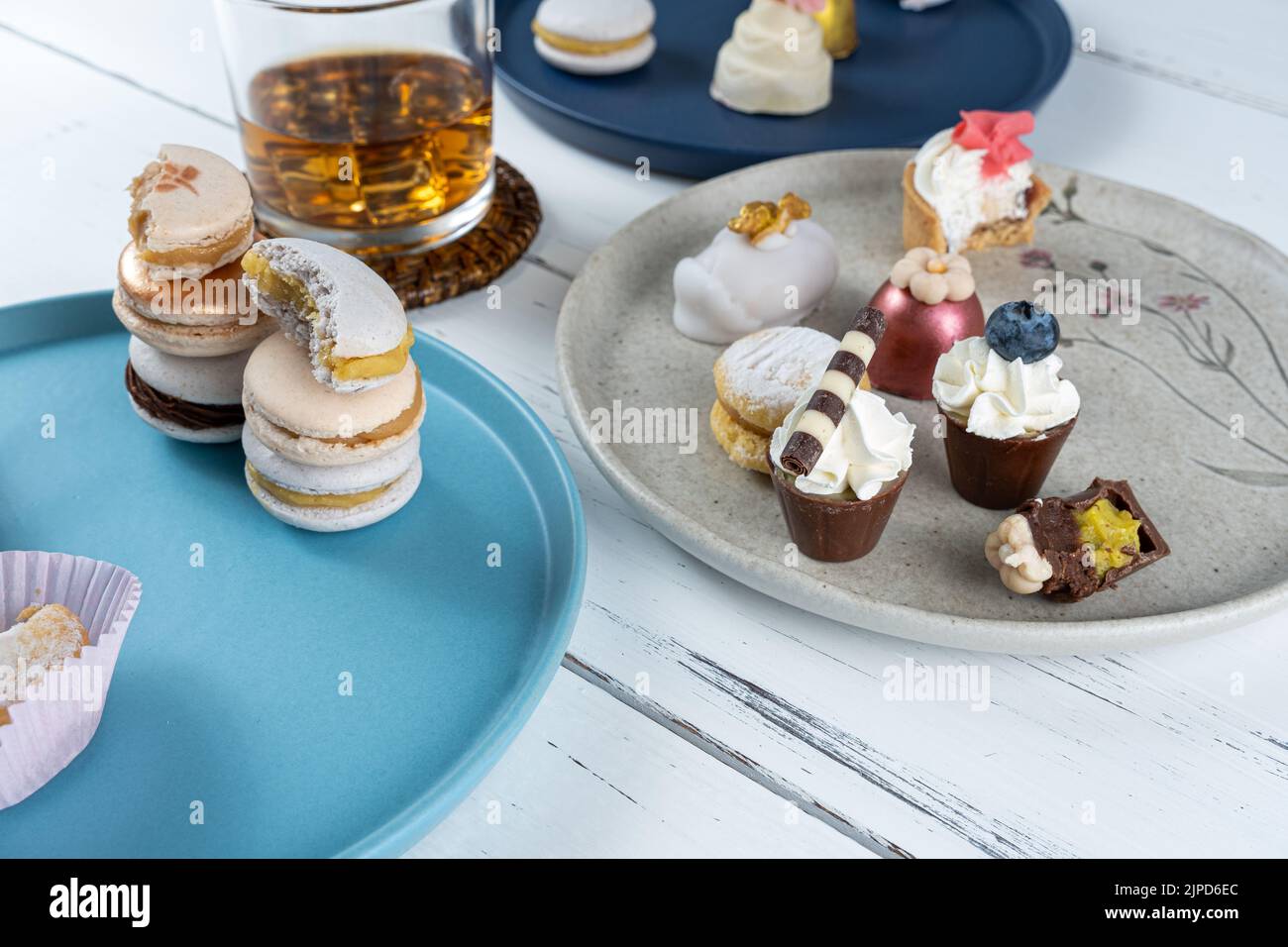 Stacked macarons surrounded by a glass of whiskey and fancy wedding ...