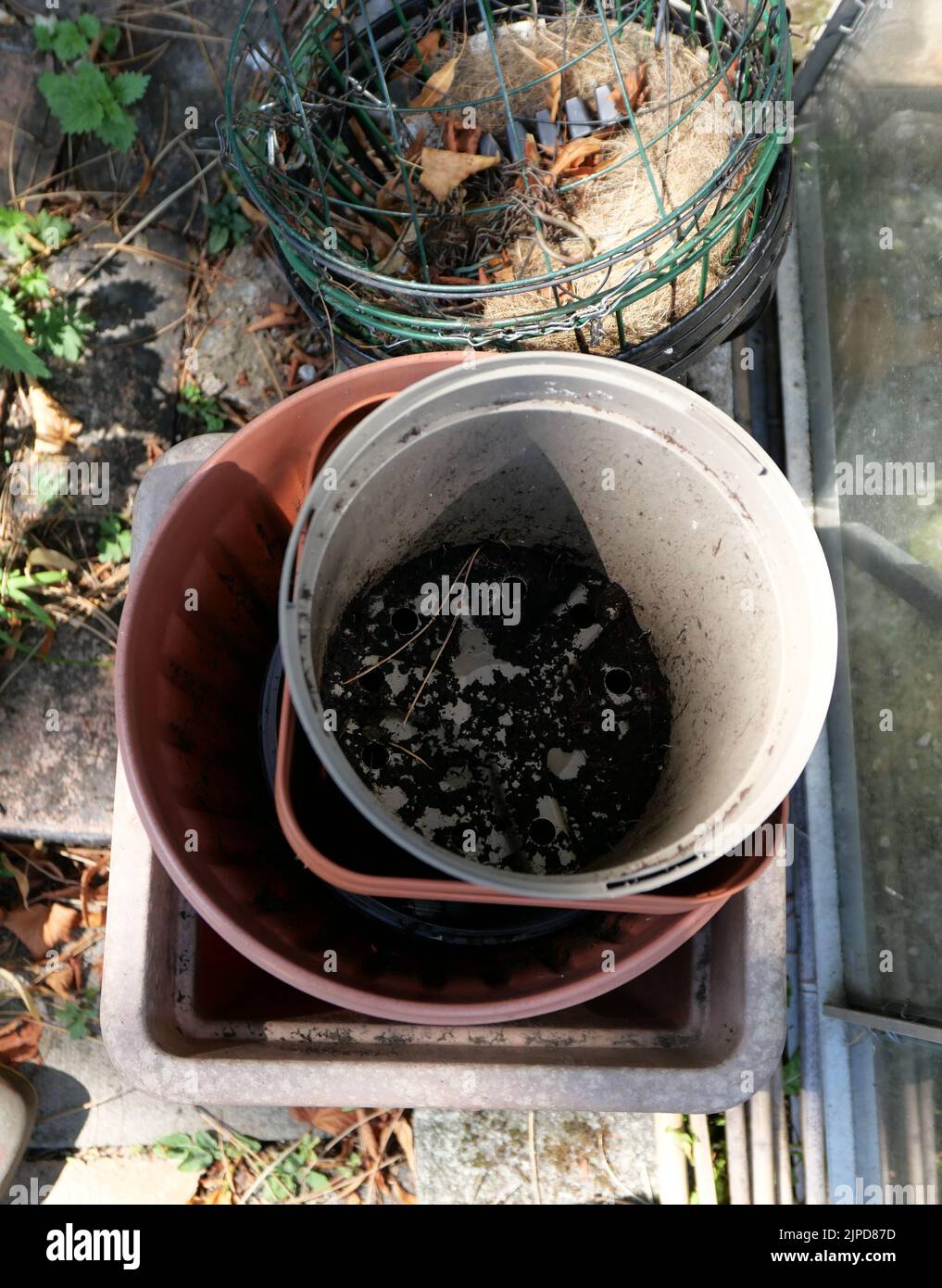 Pile of empty large flowerpots next to a greenhouse Stock Photo - Alamy