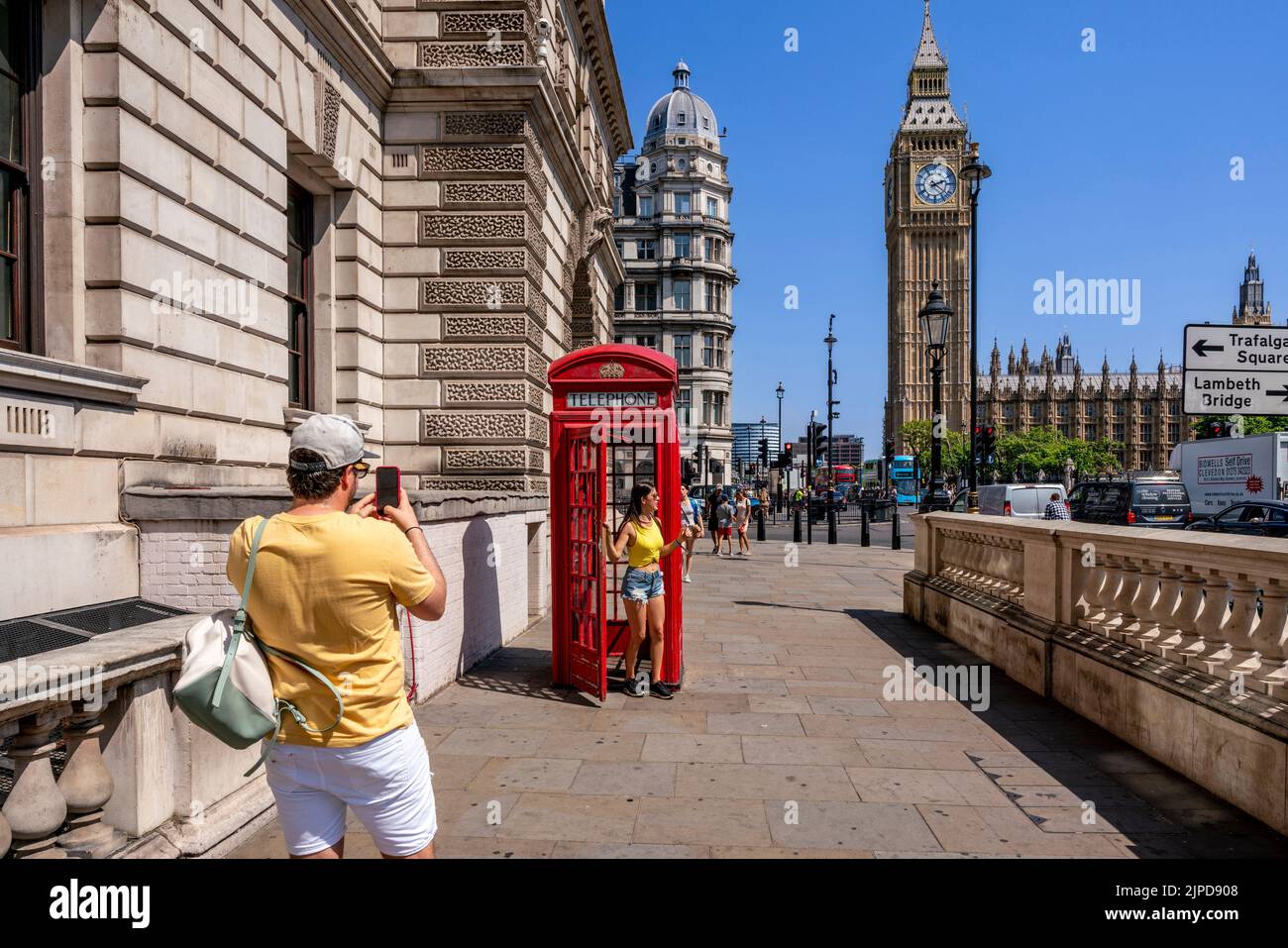 Tourists Pose For Photos Outside A Traditional Red Telephone Box In ...
