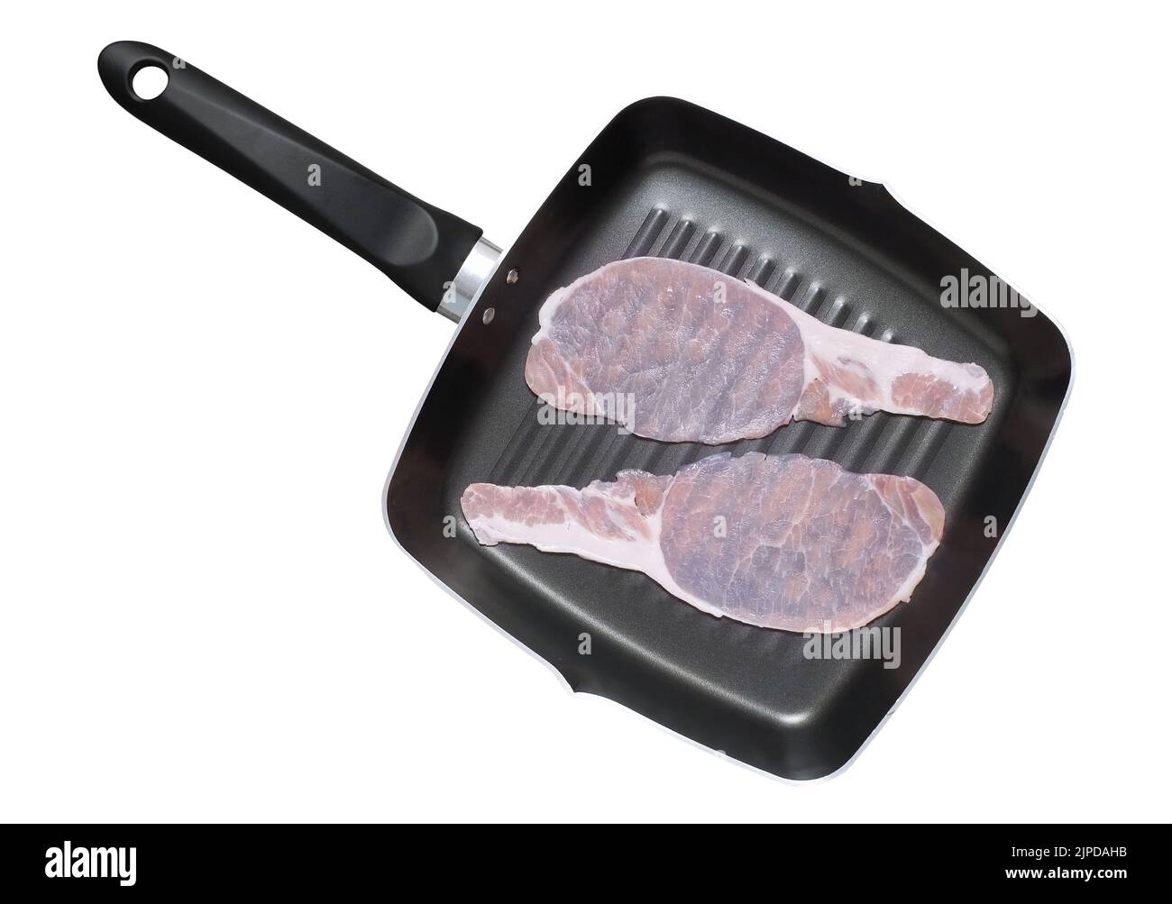Rashers or sliced raw bacon placed in a griddle frying pan. Isolated on ...