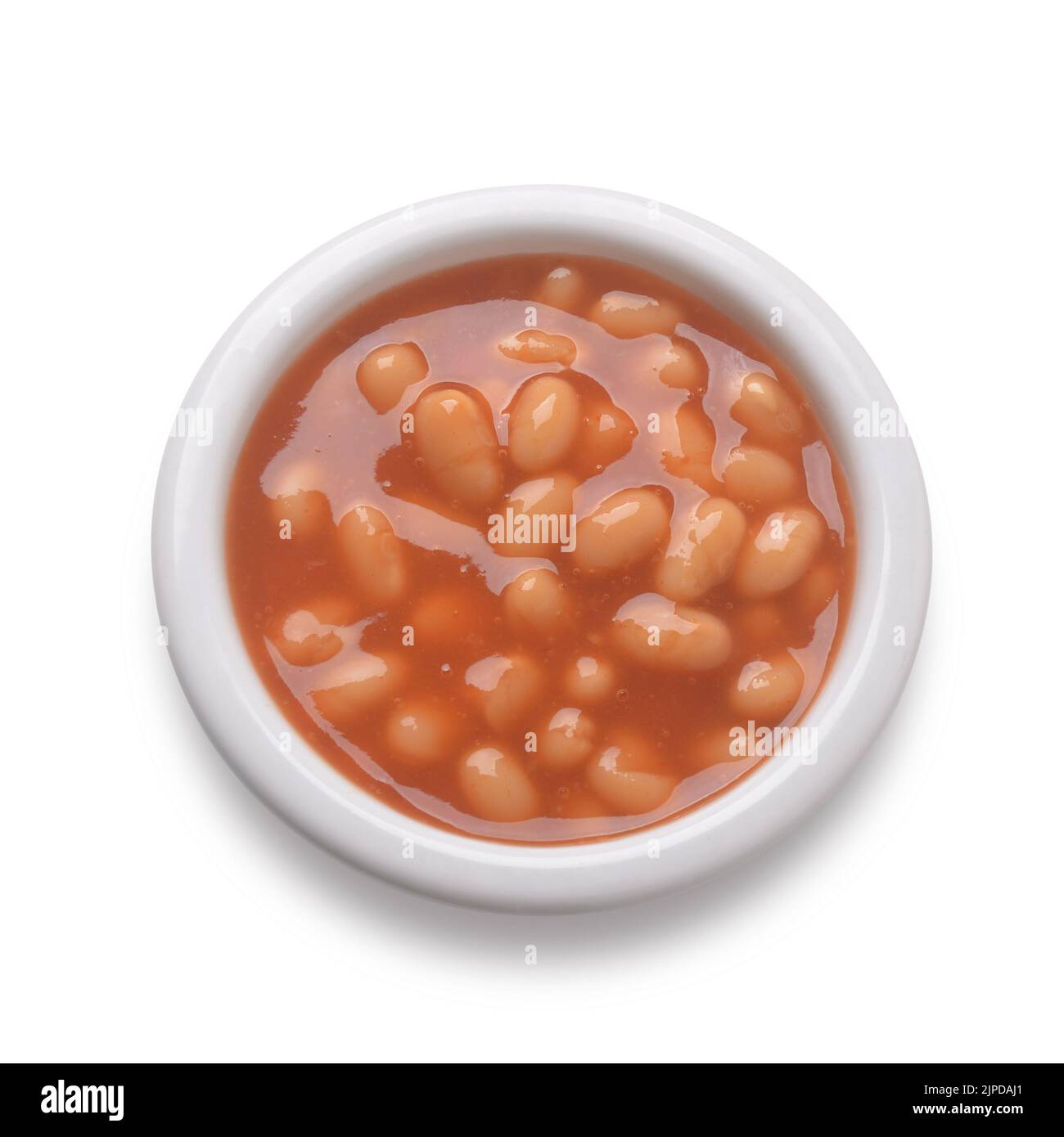 Portion of baked beans in small white bowl shot from directly above ...