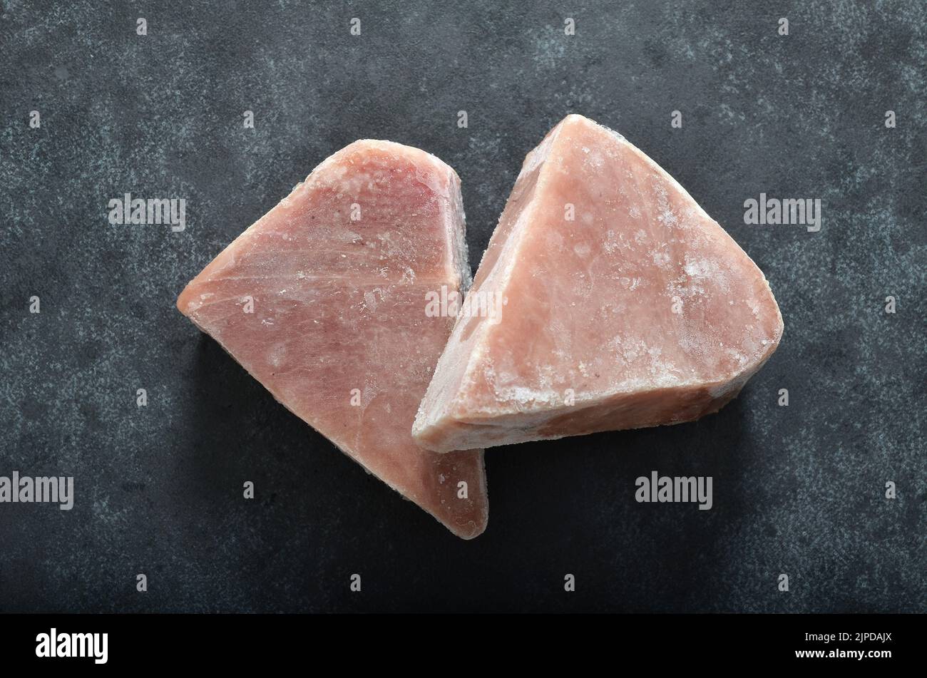 Two frozen tuna fish steaks on dark backgound shot from above Stock ...