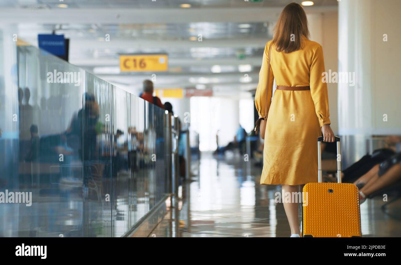 Woman walking in airport terminal. Back view Stock Photo - Alamy