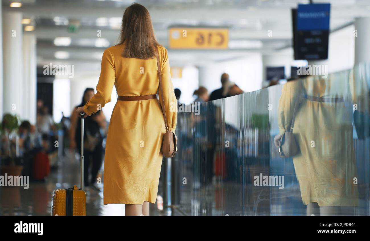 Woman walking in airport terminal. Back view Stock Photo - Alamy