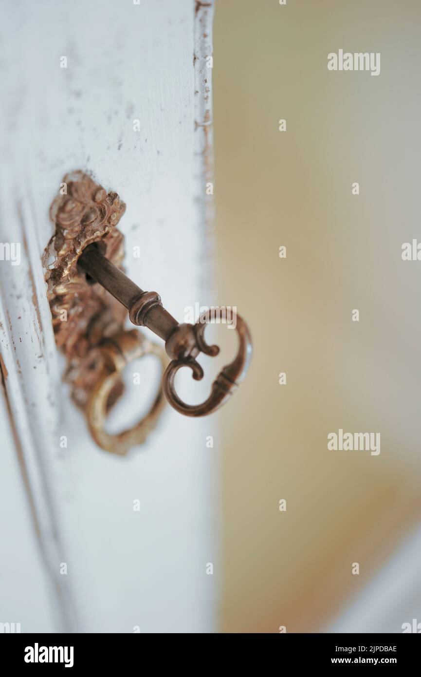 Brass ornate key in a decorative door frame Stock Photo - Alamy
