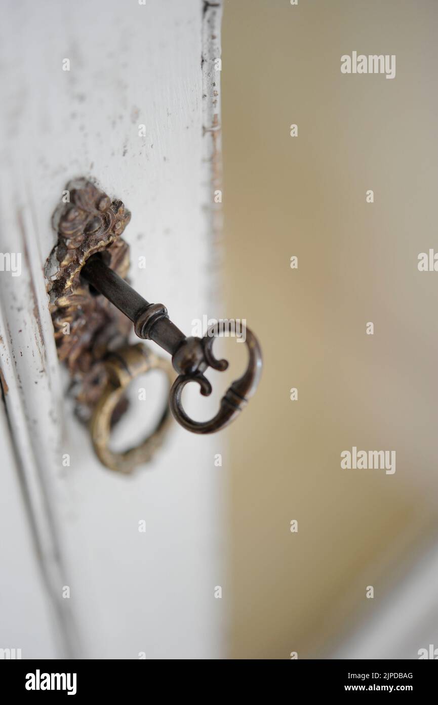 Brass ornate key in a decorative door frame Stock Photo - Alamy
