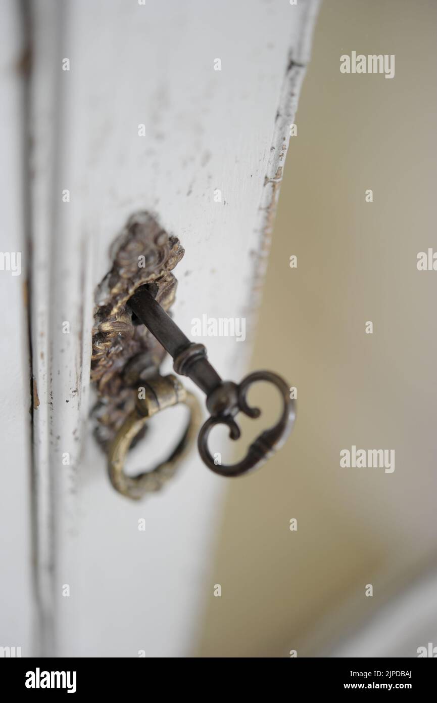 Brass ornate key in a decorative door frame Stock Photo - Alamy