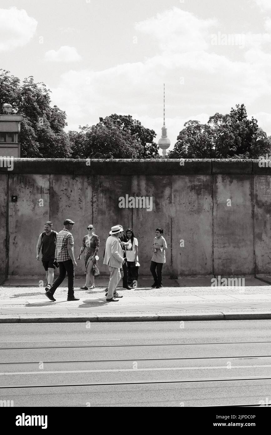 A vertical shot of people in front of the old Berlin Wall with Berlin ...