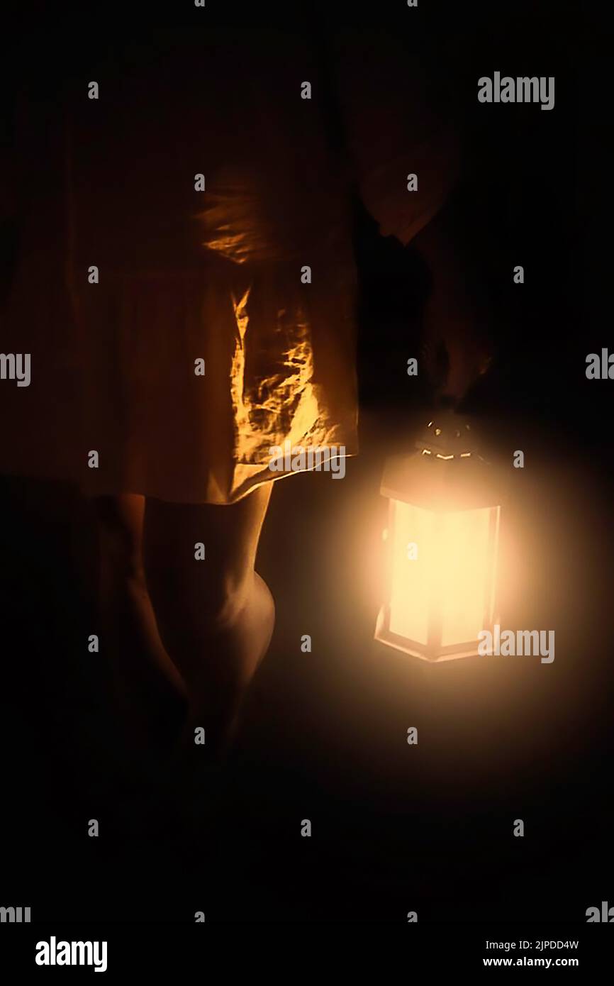 Golden lamp girl walking in darkness Stock Photo - Alamy