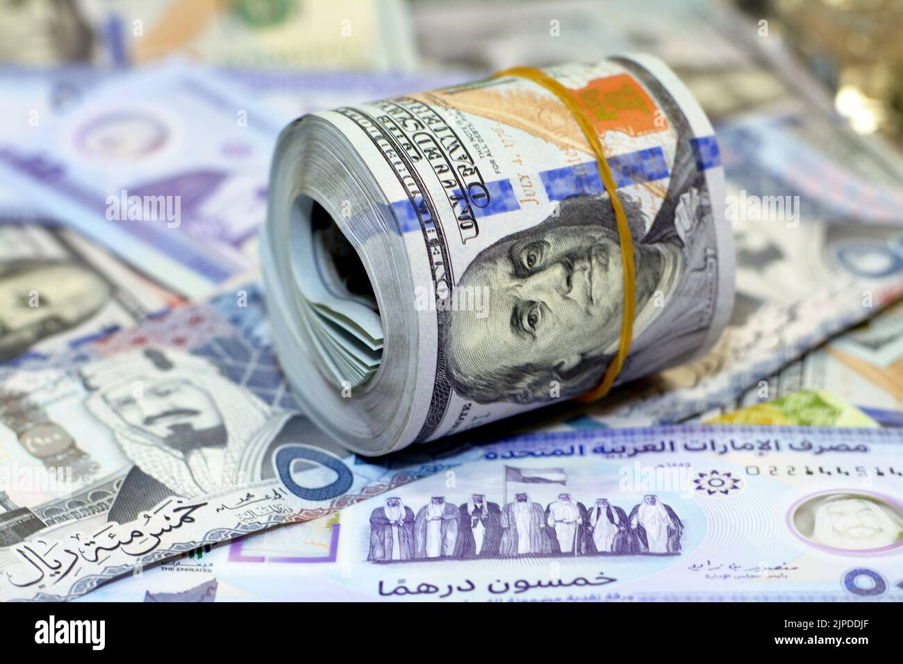 American money roll with a band on a pile of American dollar bills ...