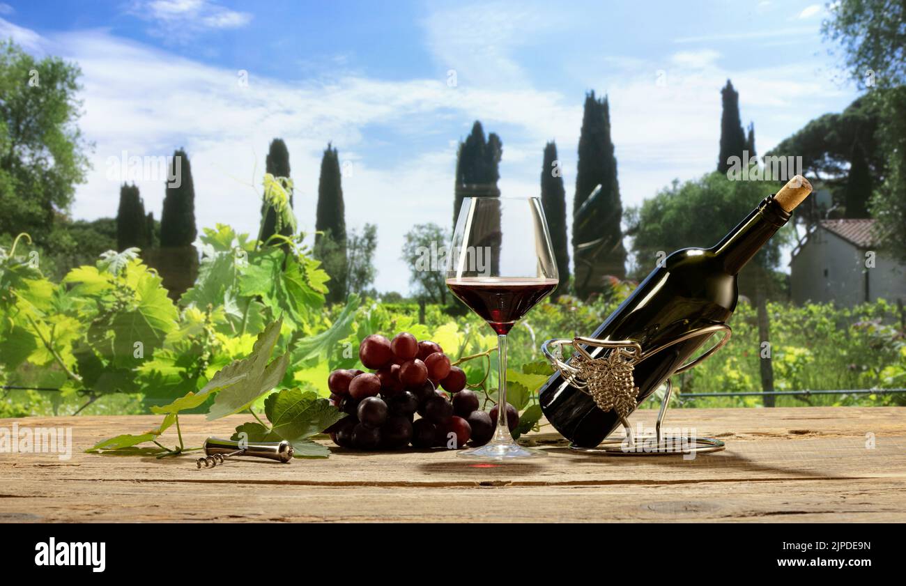 Bottle and glass of delicious red wine on wooden table isolated over ...