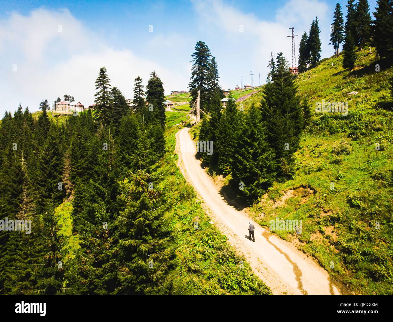 Elderly fit man walk uphill to home village in nature in Georgia ...