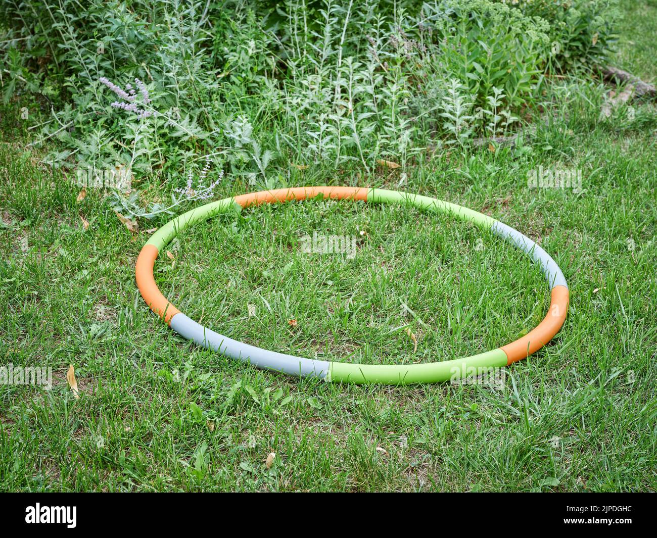 weighted hula hoop on a backyard lawn in summer scenery, core workout ...