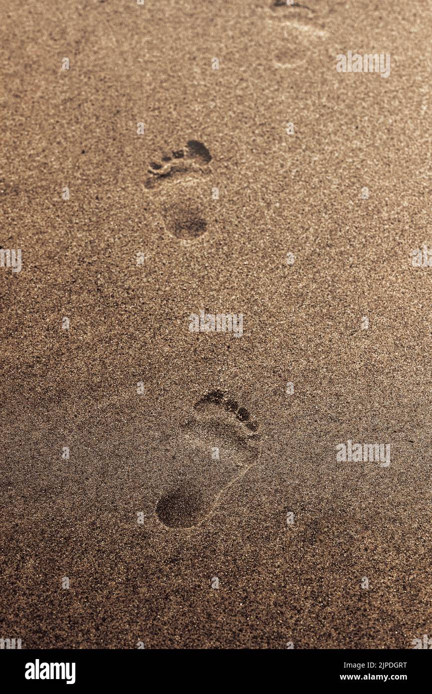 A footprint of human feet on the sand on the beach, structure abstract ...