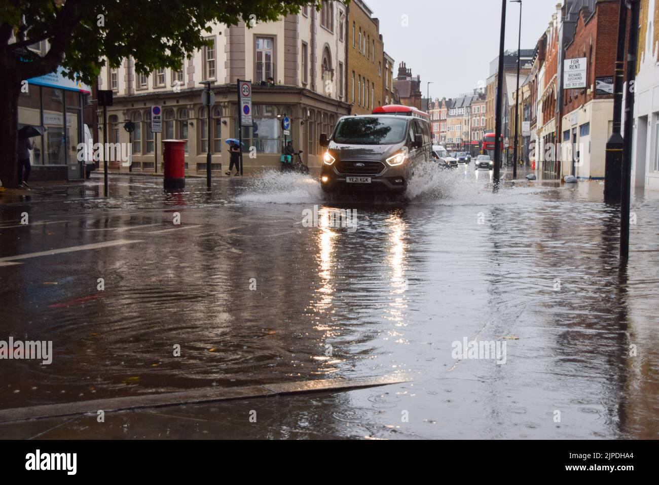 London, UK. 17th August 2022. A car splashes through a flooded King's ...