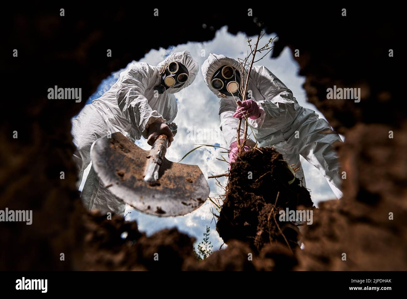 Post apocalypse - people in gas masks using shovel for reforesting soil ...