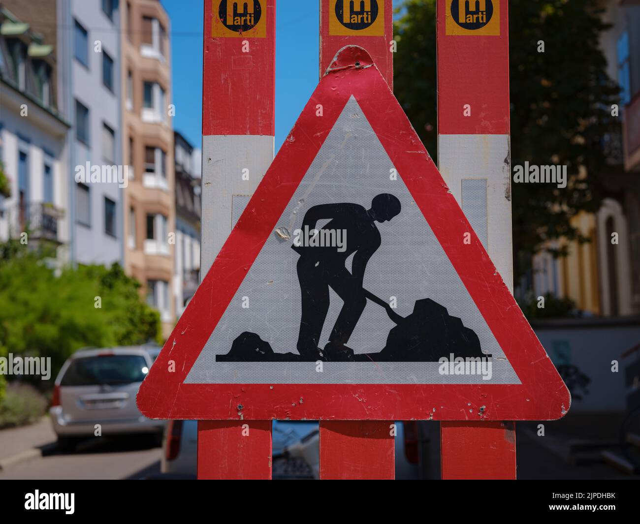 Man At Work Sign On Road. Construction warning sign on blur traffic ...