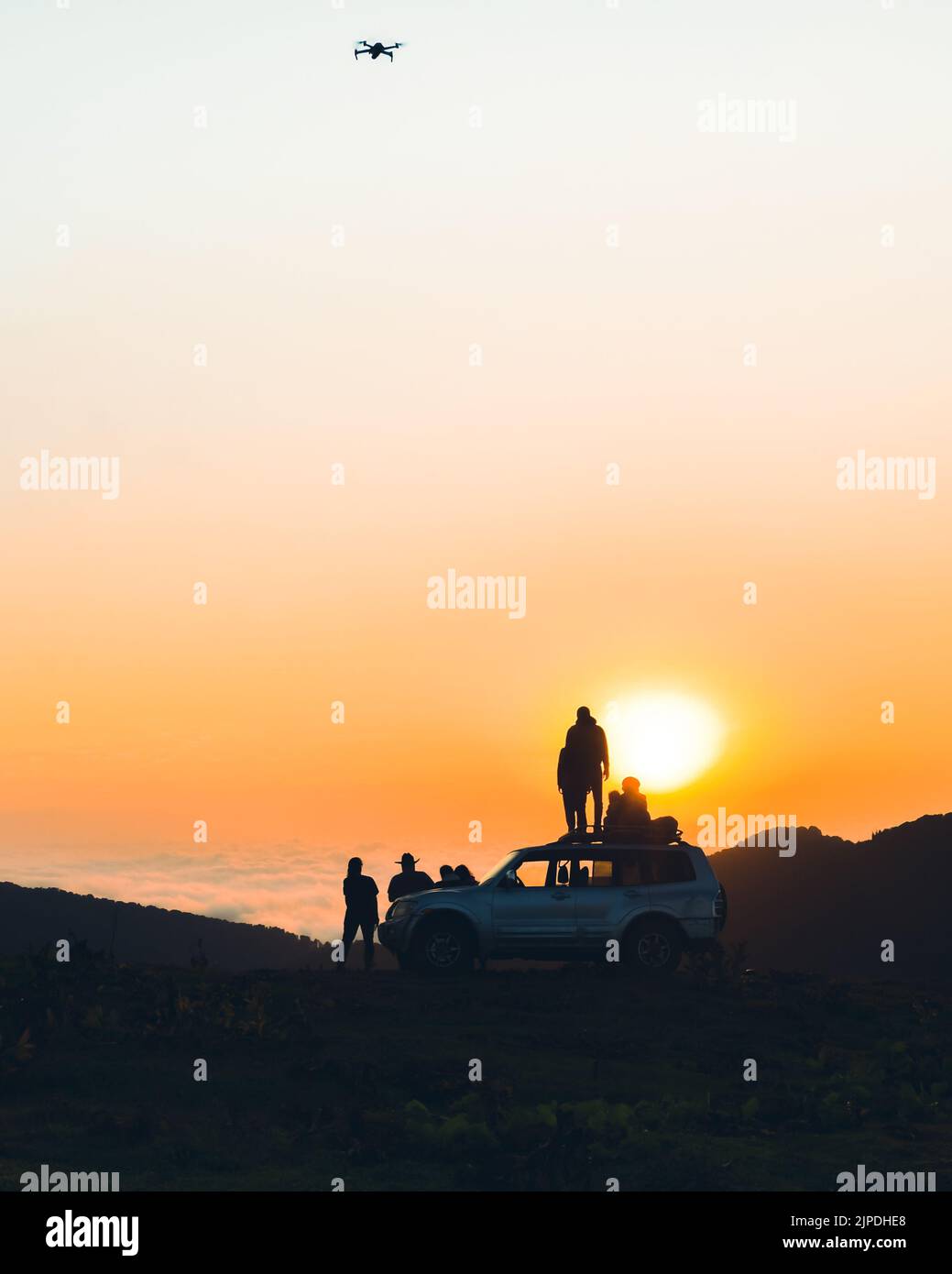 Group of travelers content creators stand by 4wd vehicle together ...