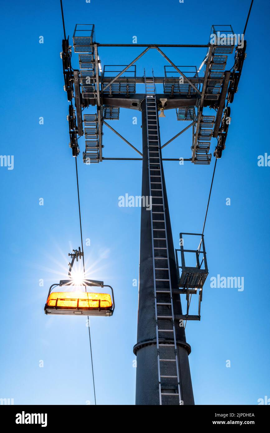 Empty ski-lift chair and cable car mast on blue sky background Stock ...