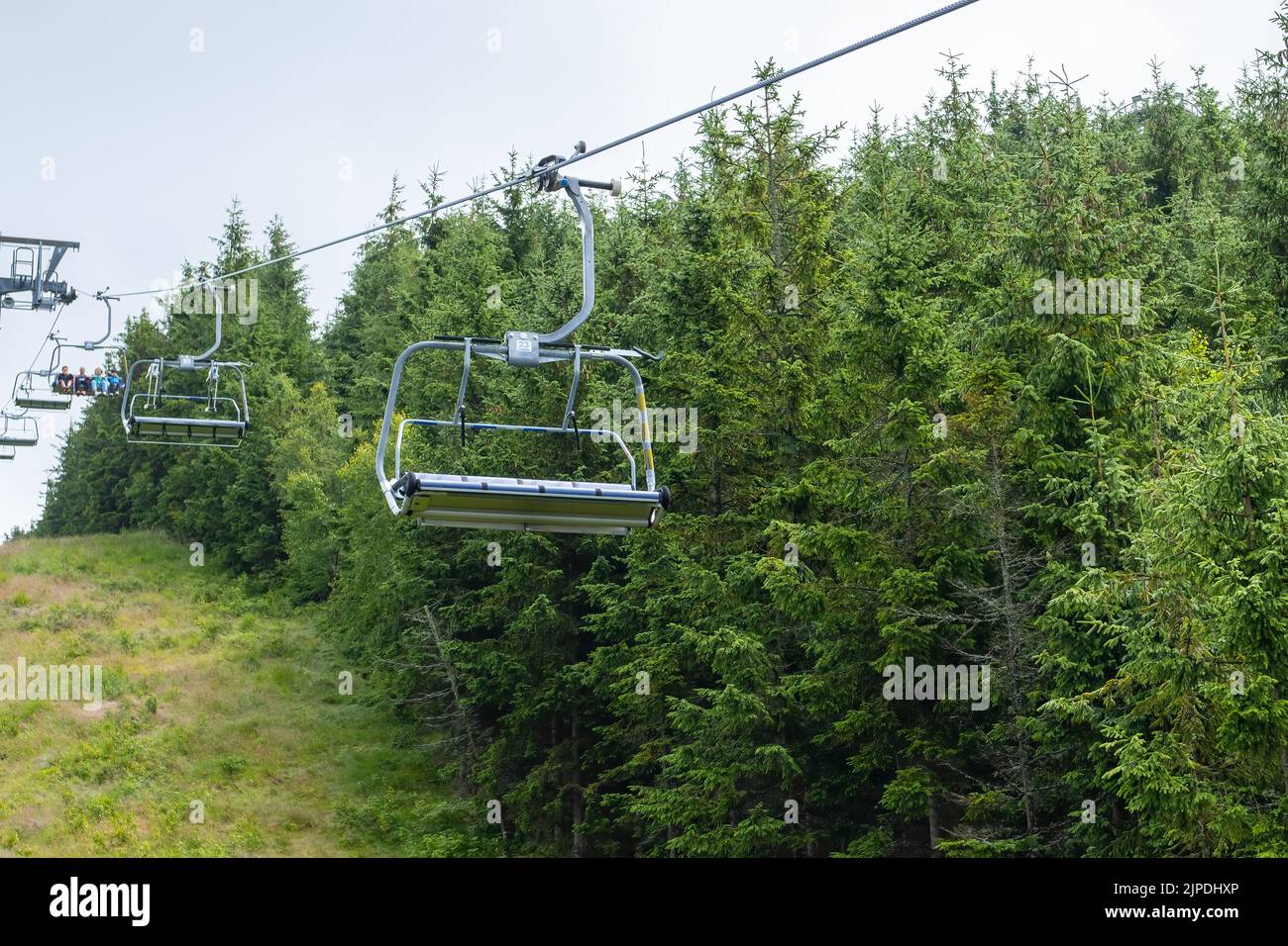 Chairlift chairs going in highland. Huge tourist complex located among ...