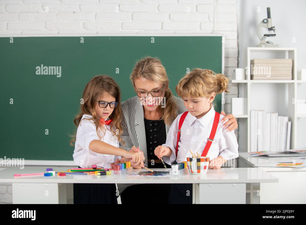 Schoolkids drawing with teacher. Children from elementary school study ...