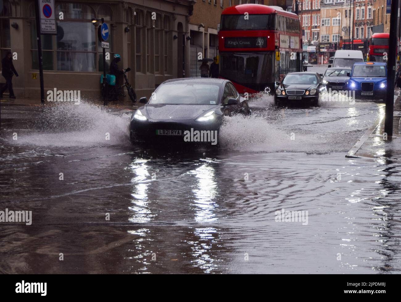 London, England, UK. 17th Aug, 2022. A car splashes through a flooded ...