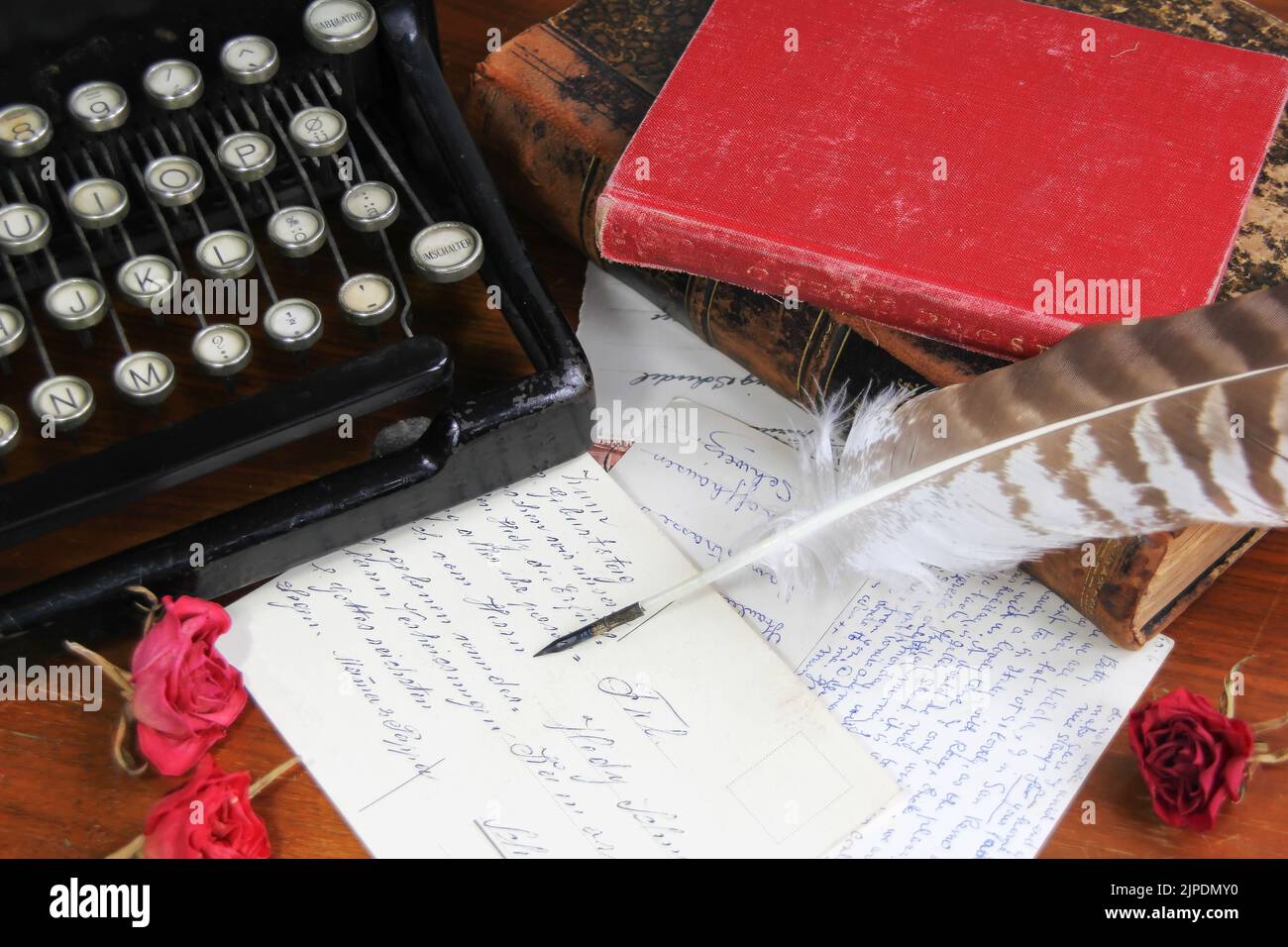 Classic type writer with old postcards and feather pen (focus on ...