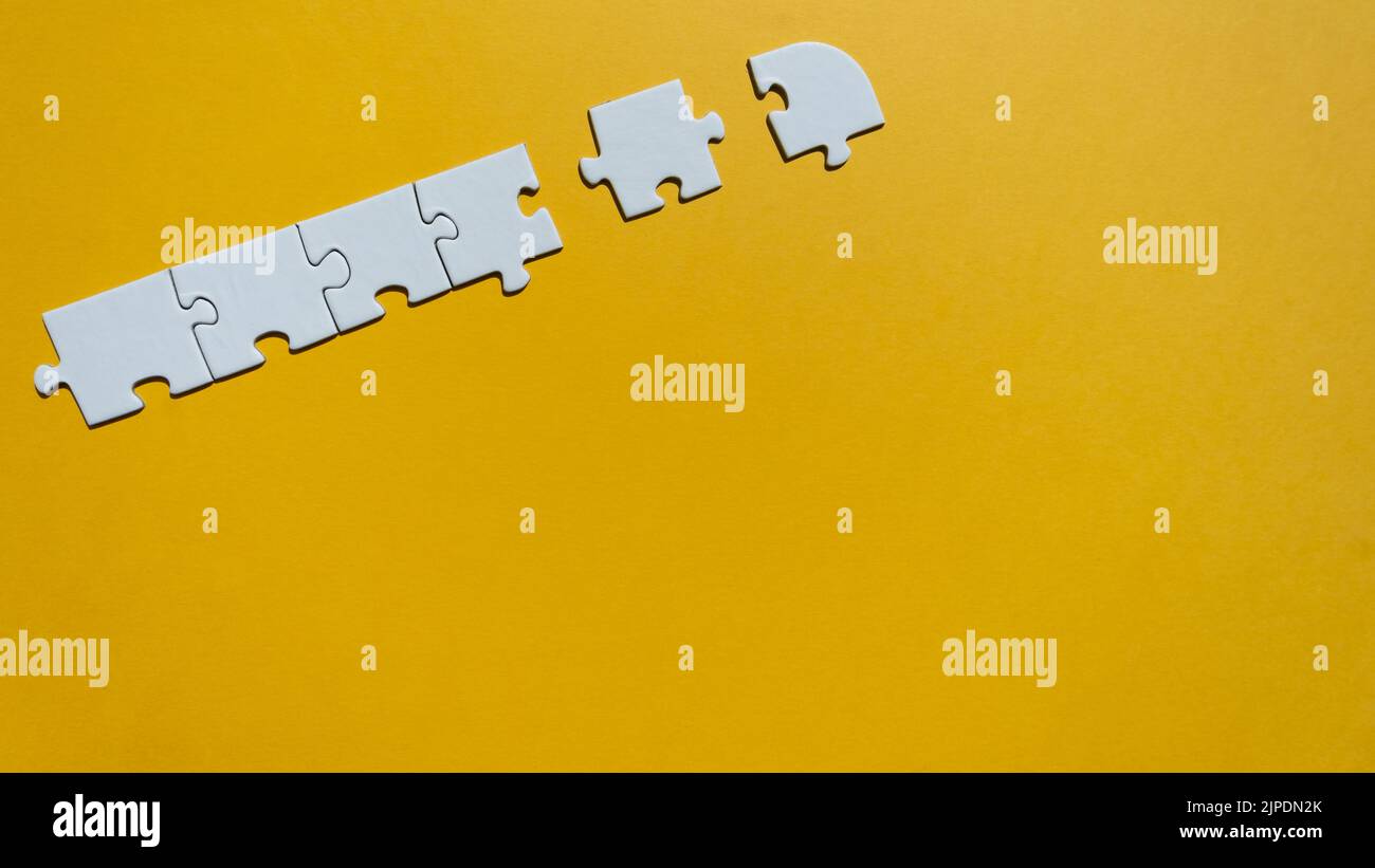 White puzzle pieces on the yellow background. Concept of board game ...